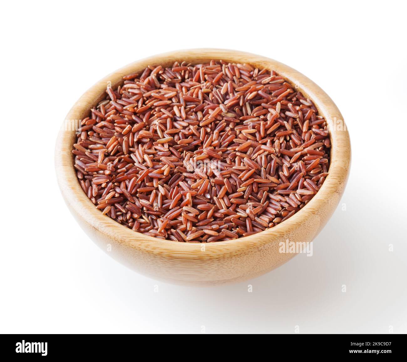 Uncooked red rice in wooden bowl isolated on white background with ...
