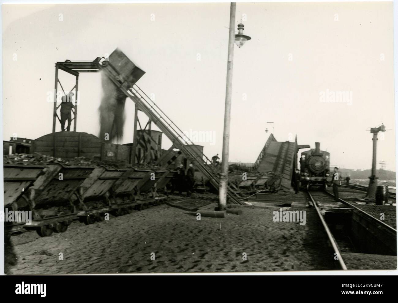 Tipping ash from the steam locomotive over to freight wagons Stock ...