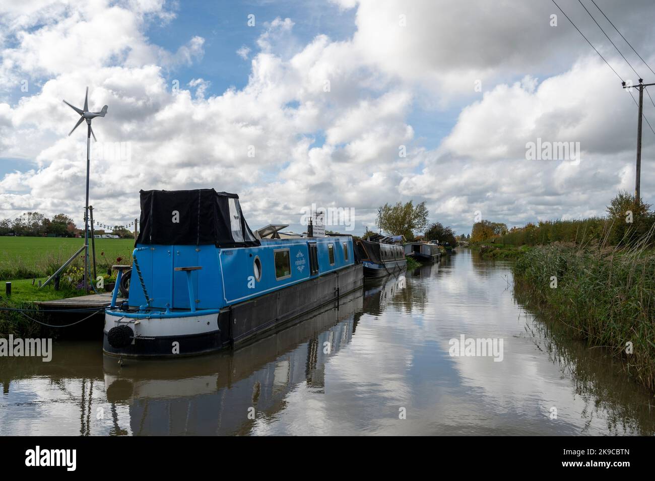 Traditional narrow boats and barges with a small windmill to power ...