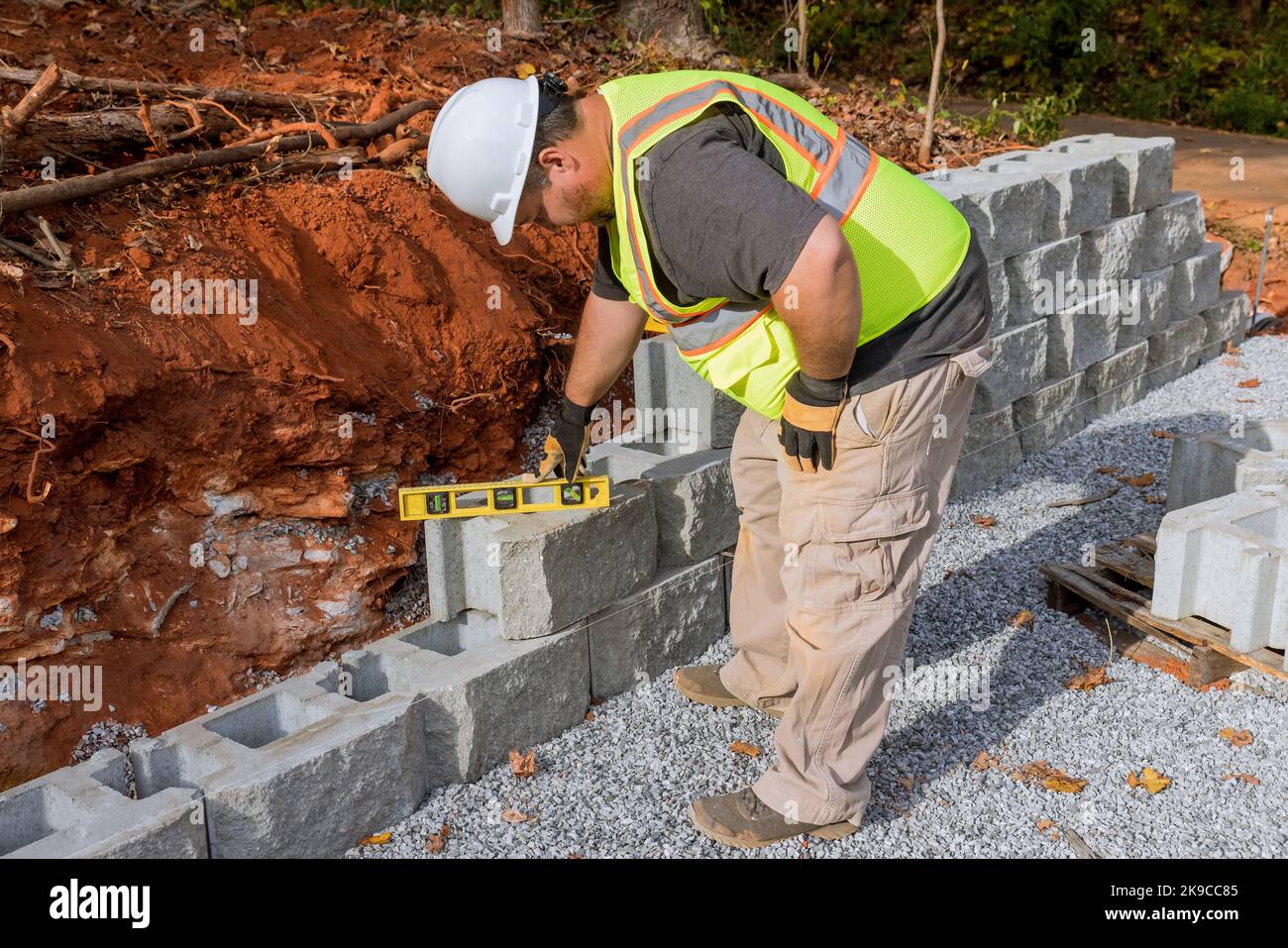 Contractor during installation of new large block retaining wall in ...