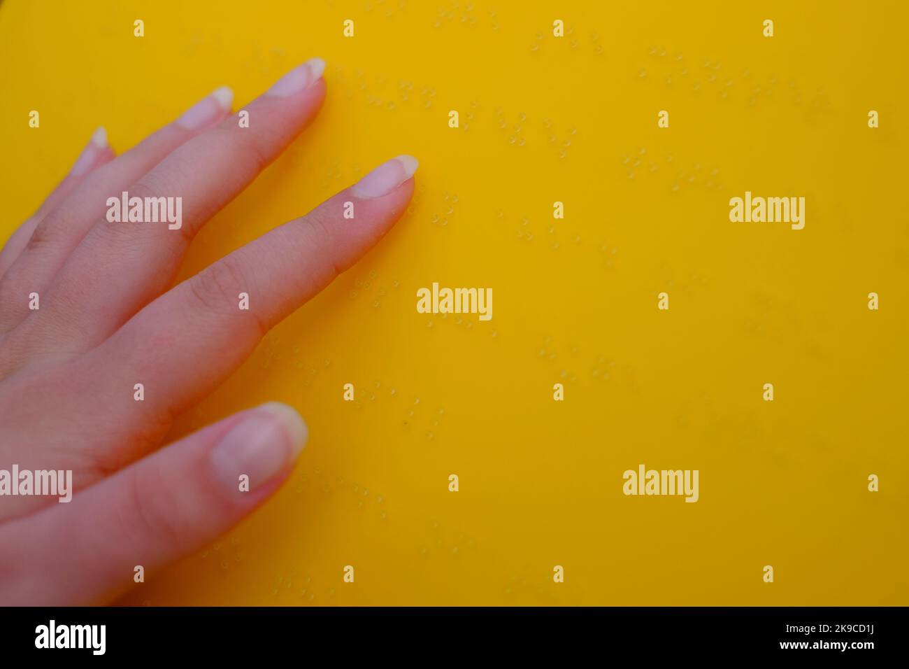 Blind visually impaired person reading braille on public information ...