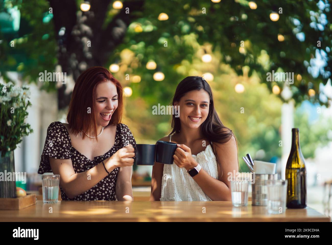 Two friends drinking coffee - women clinking with cups of coffee Stock ...