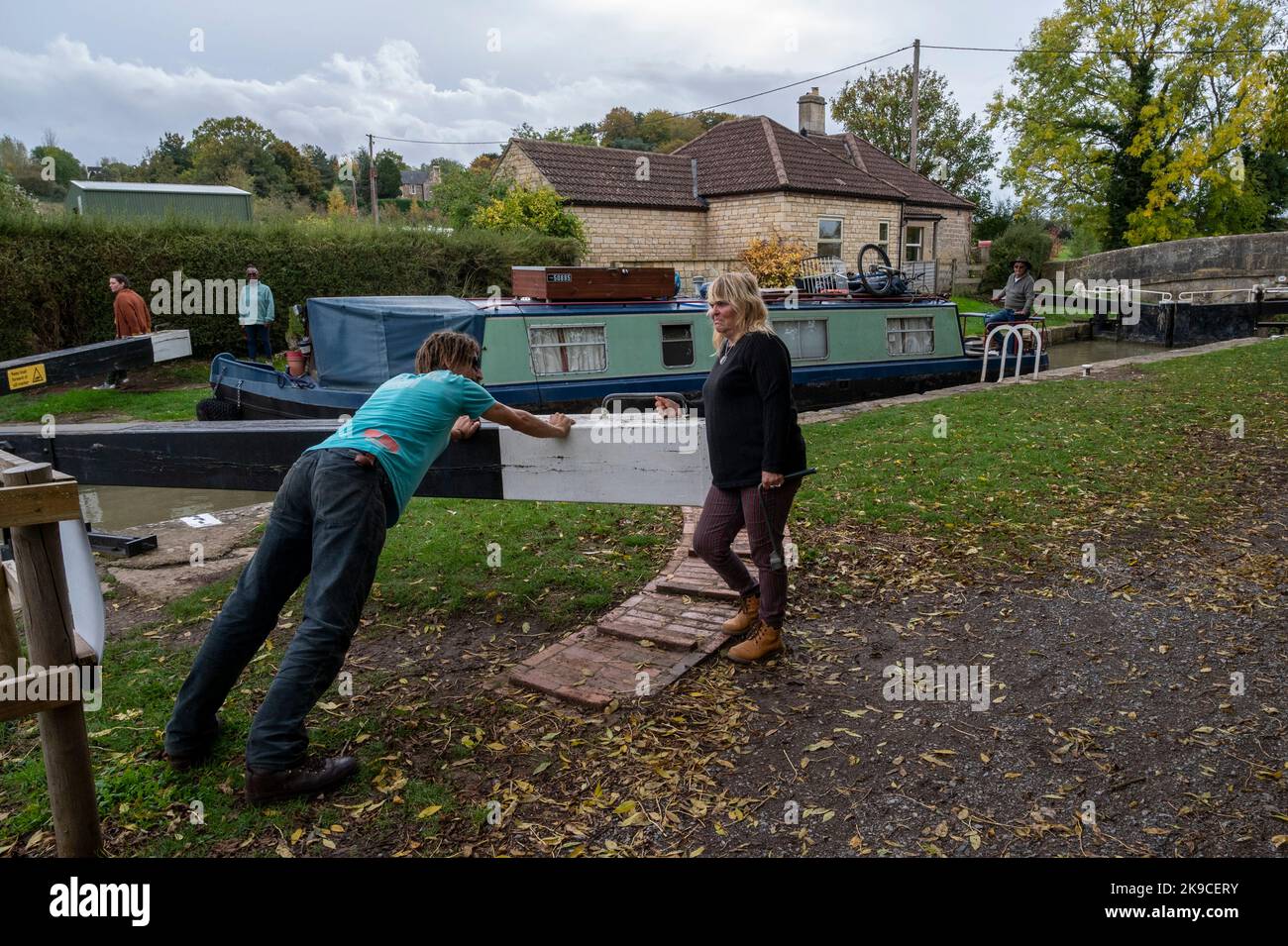 Young man and woman opening the lock gates at Seend Top Lock, Kennet ...