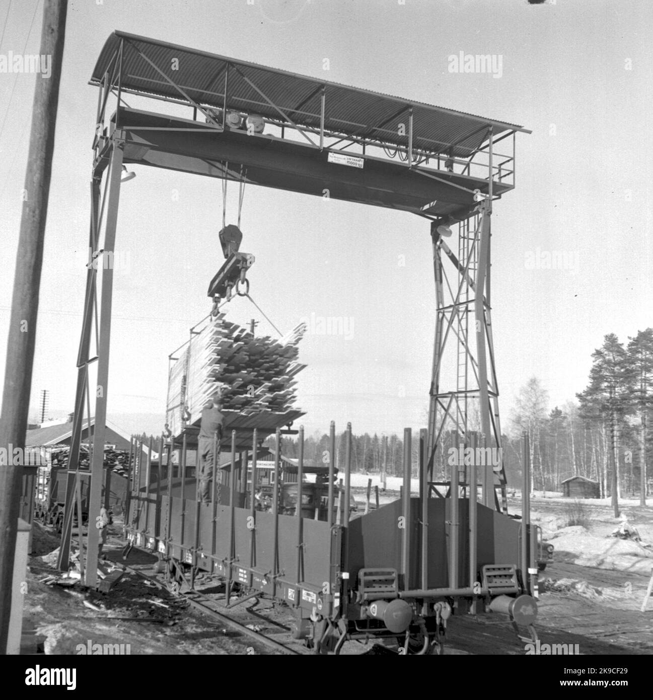 Loading of wood with goat crane Stock Photo - Alamy