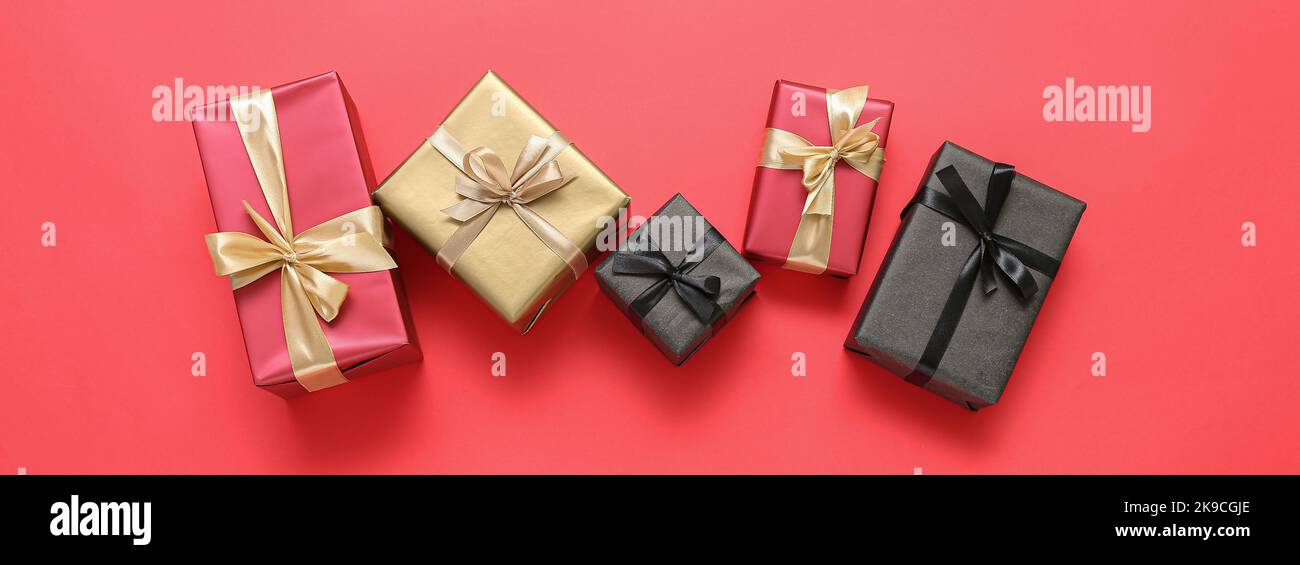 Different gift boxes on red background, top view Stock Photo - Alamy