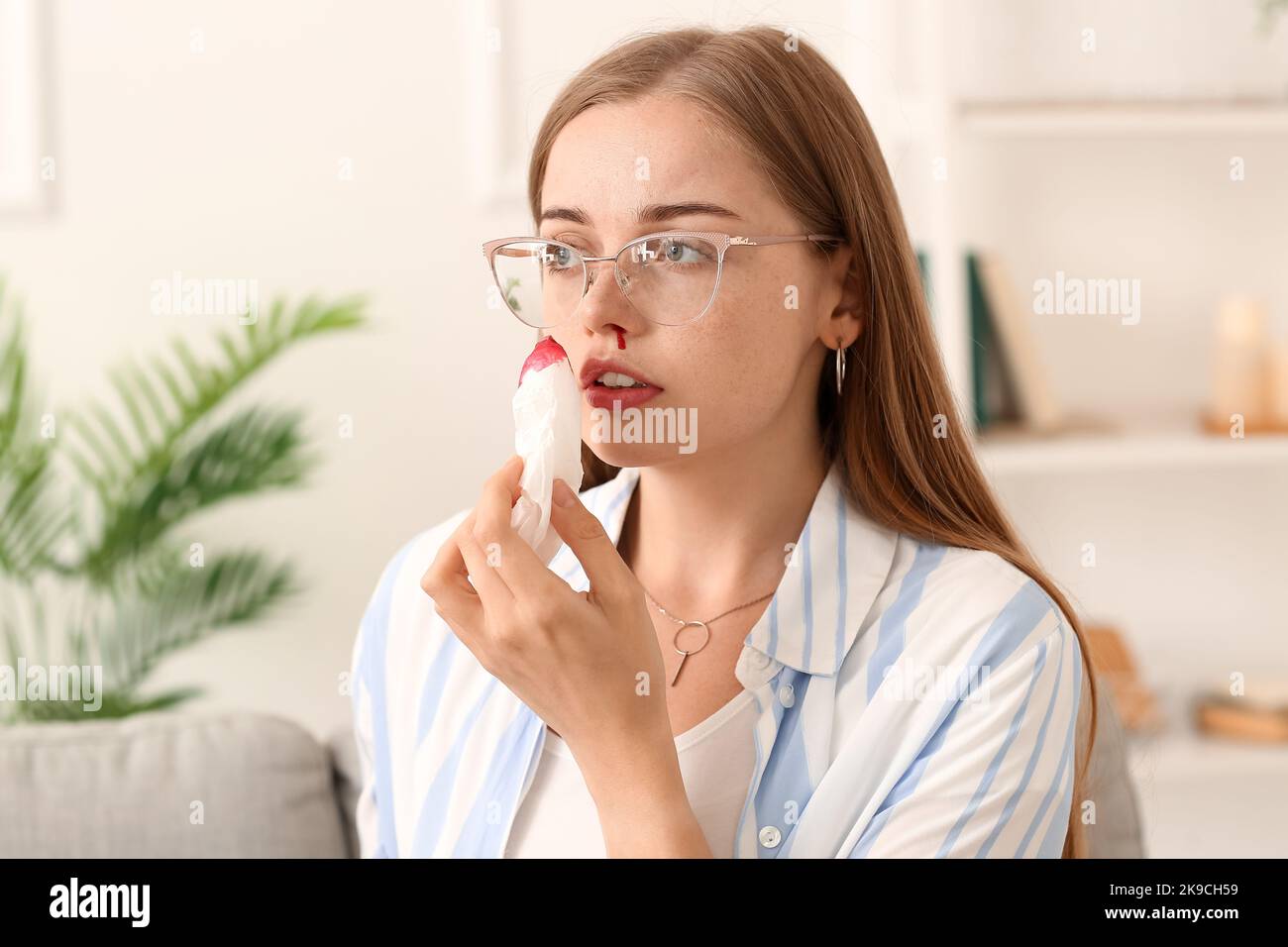 Young woman wiping nosebleed with tissue at home, closeup Stock Photo ...