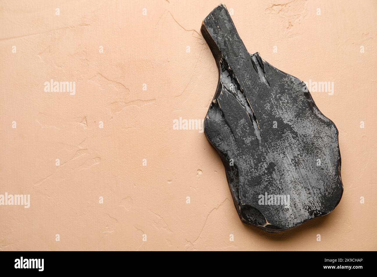 Black wooden cutting board on beige background Stock Photo - Alamy