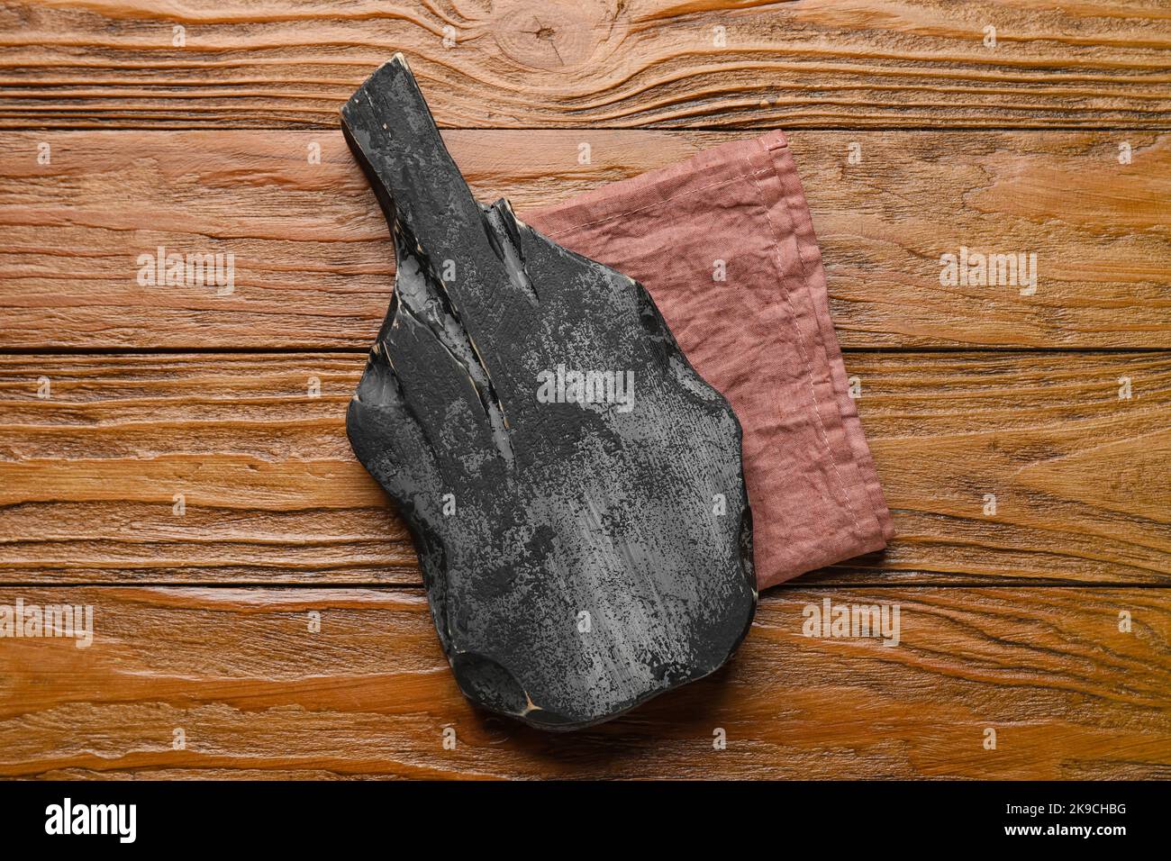 Black cutting board with napkin on wooden background Stock Photo - Alamy
