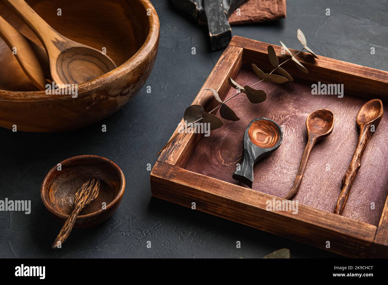 Wooden cooking utensils and eucalyptus branch on dark background Stock ...