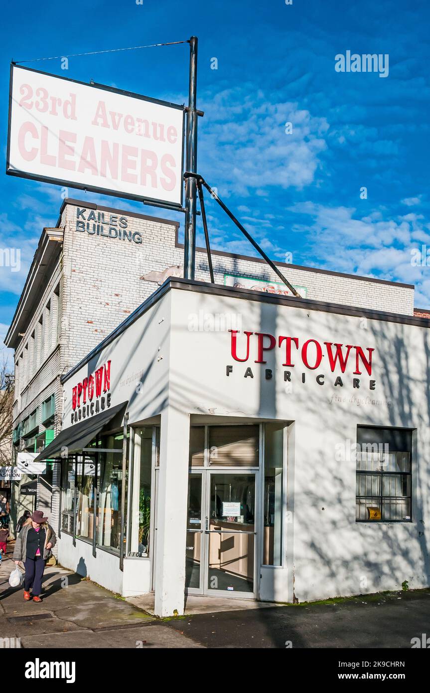 A woman in a hat walks past Uptown Fabricare storefront in Portland ...
