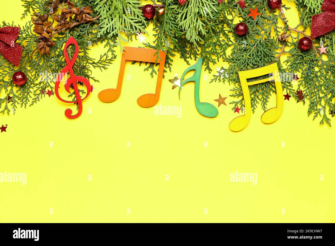 Note signs with Christmas decor and coniferous branches on yellow ...
