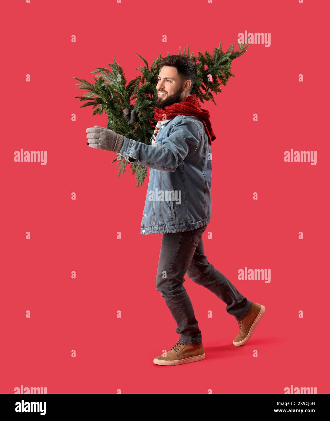 Handsome man with Christmas tree on red background Stock Photo - Alamy