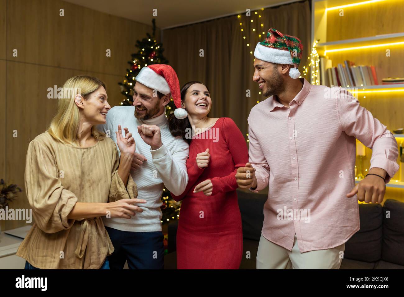Four diverse friends at New Year's party celebrating and dancing, house ...