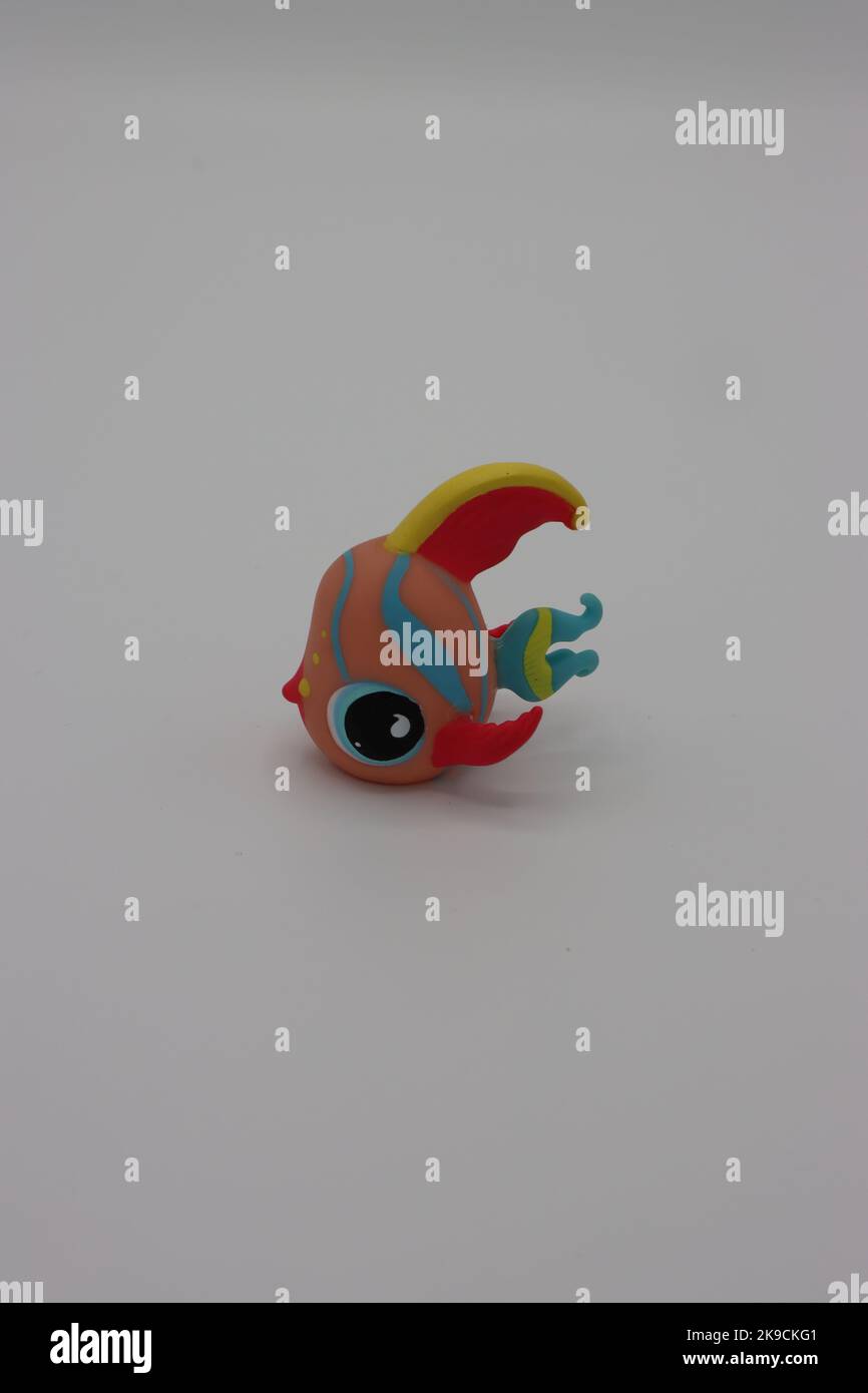 Tiny, cute plastic fish animal figure on a white background ...