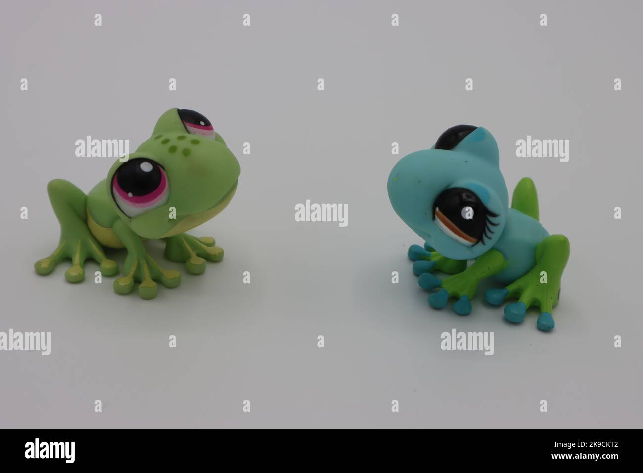 Tiny, cute plastic frog animal figures on a white background ...