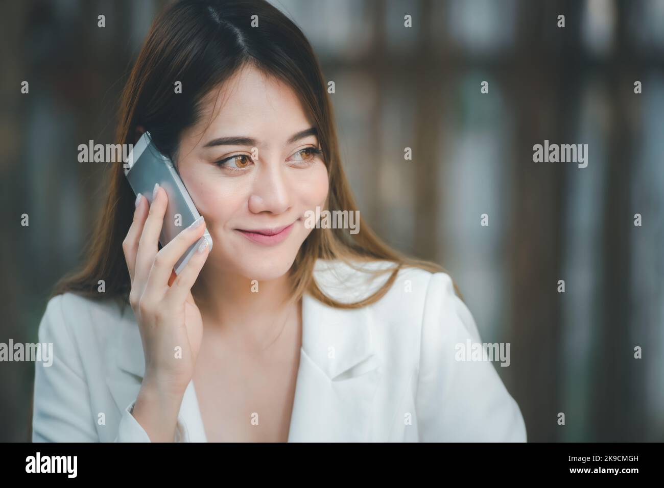 Happy Young Asian executive business woman in marketing working talking ... Happy Young Asian executive business woman in marketing working talking ...