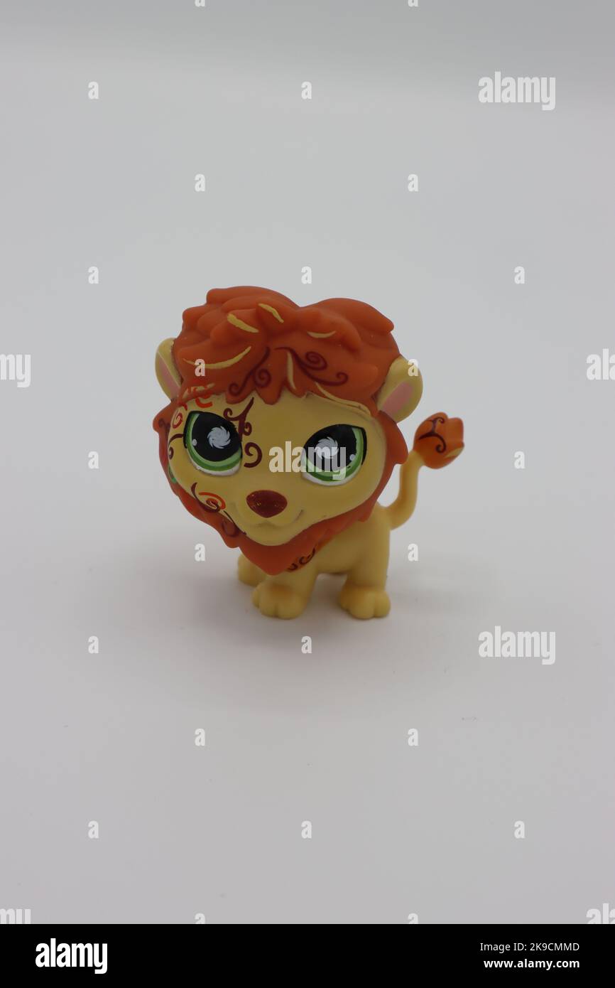 Tiny, cute plastic lion animal figure on a white background ...