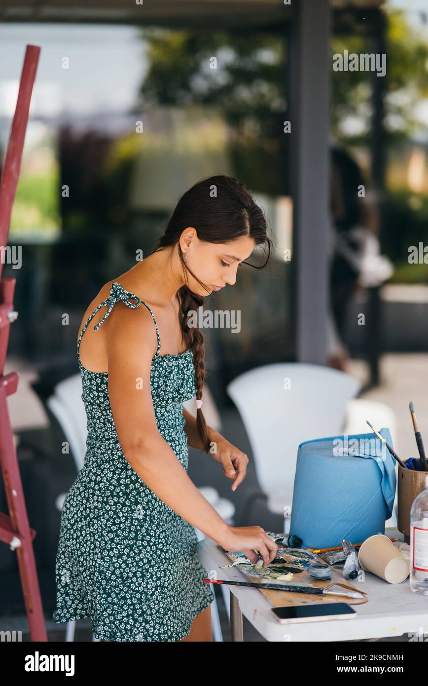 Young woman artist stands close table with a palette Stock Photo - Alamy