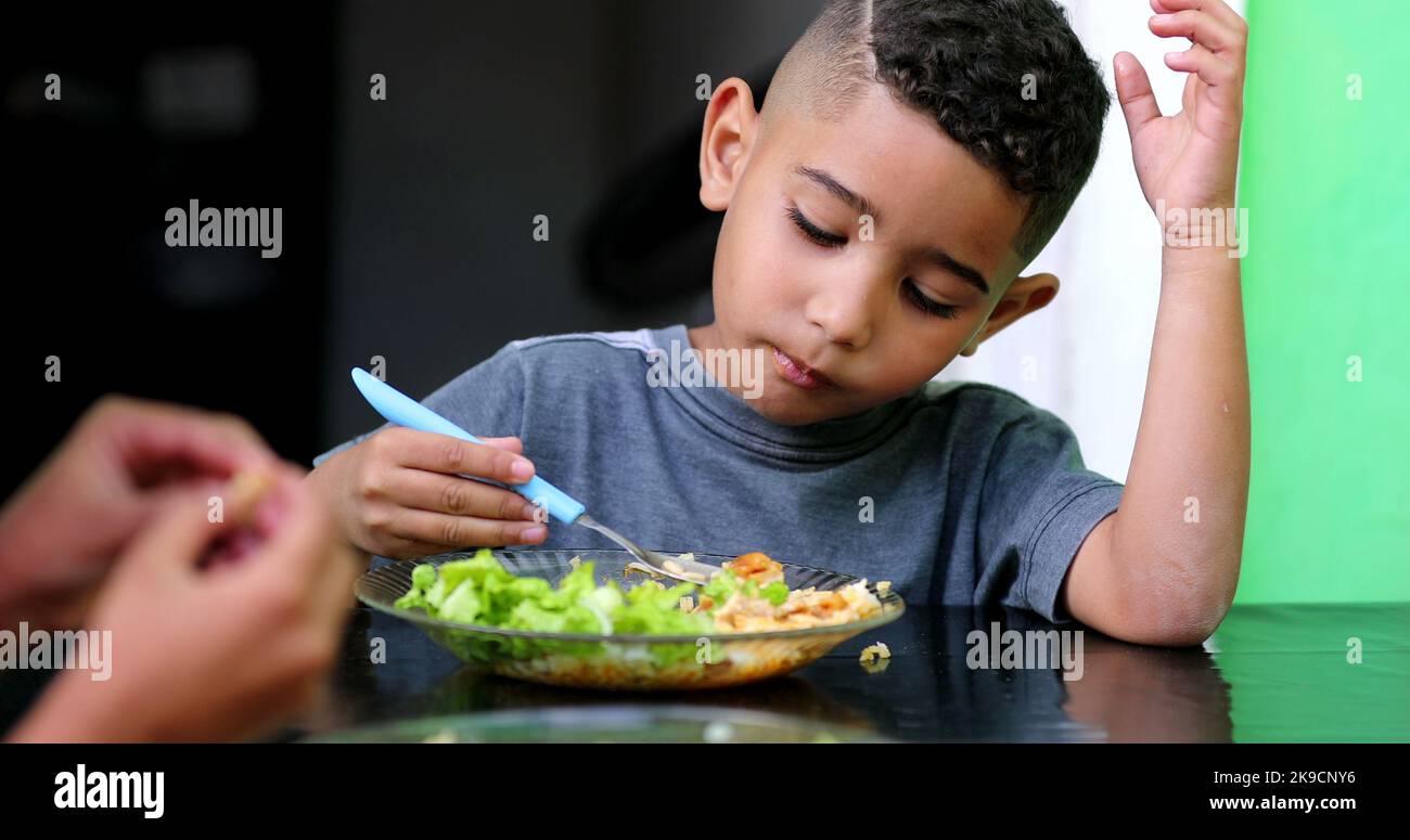 Brazilian boy eating lunch. Mixed race hispanic kid eats lunch Stock ...