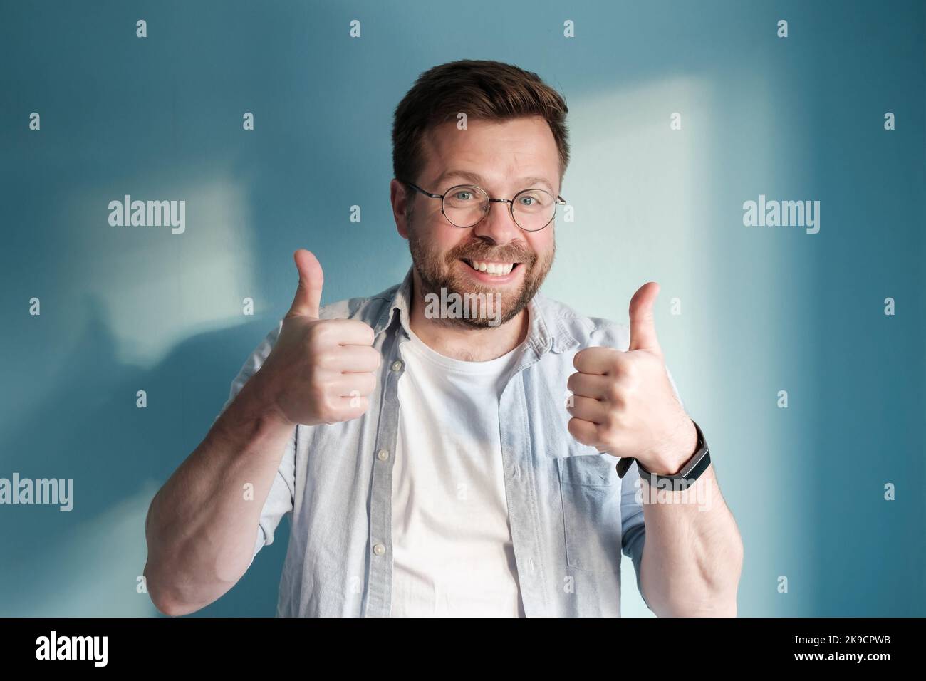 Man showing thumbs up. European smiles and makes an approving gesture ...