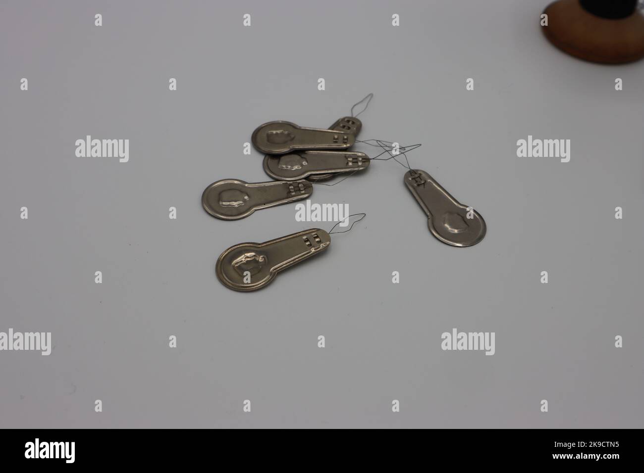 Sewing accessories on a white background. A bunch of needle threaders ...