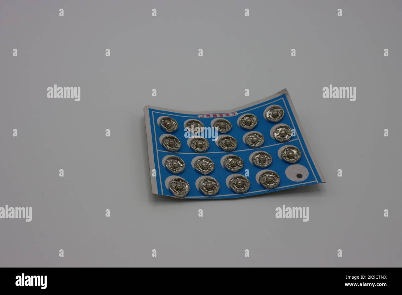 Sewing accessories on a white background. Snap fasteners on a paper ...