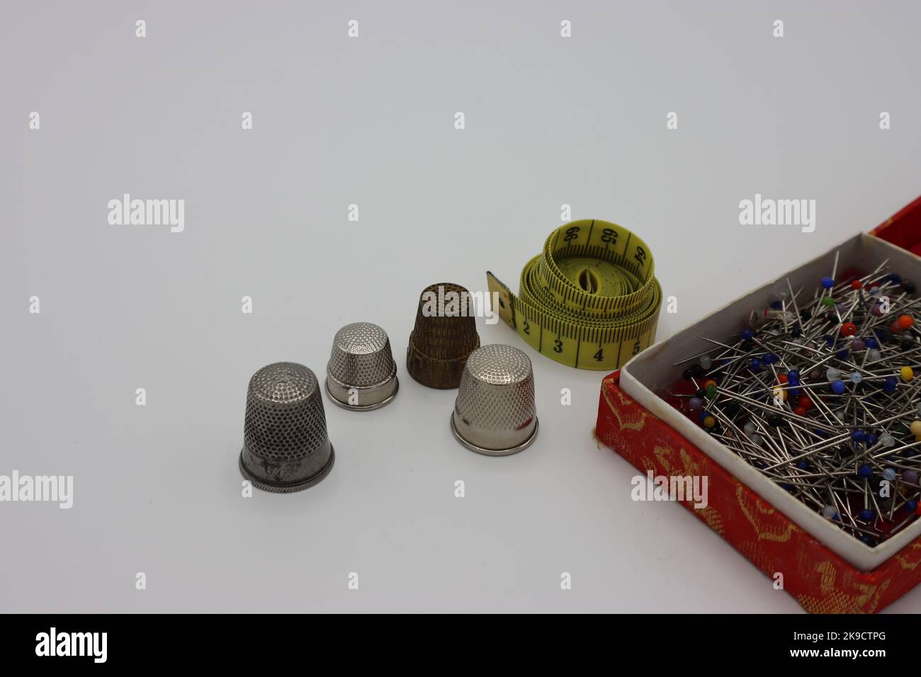 Sewing accessories on a white background. Thimbles, measure tape and a ...