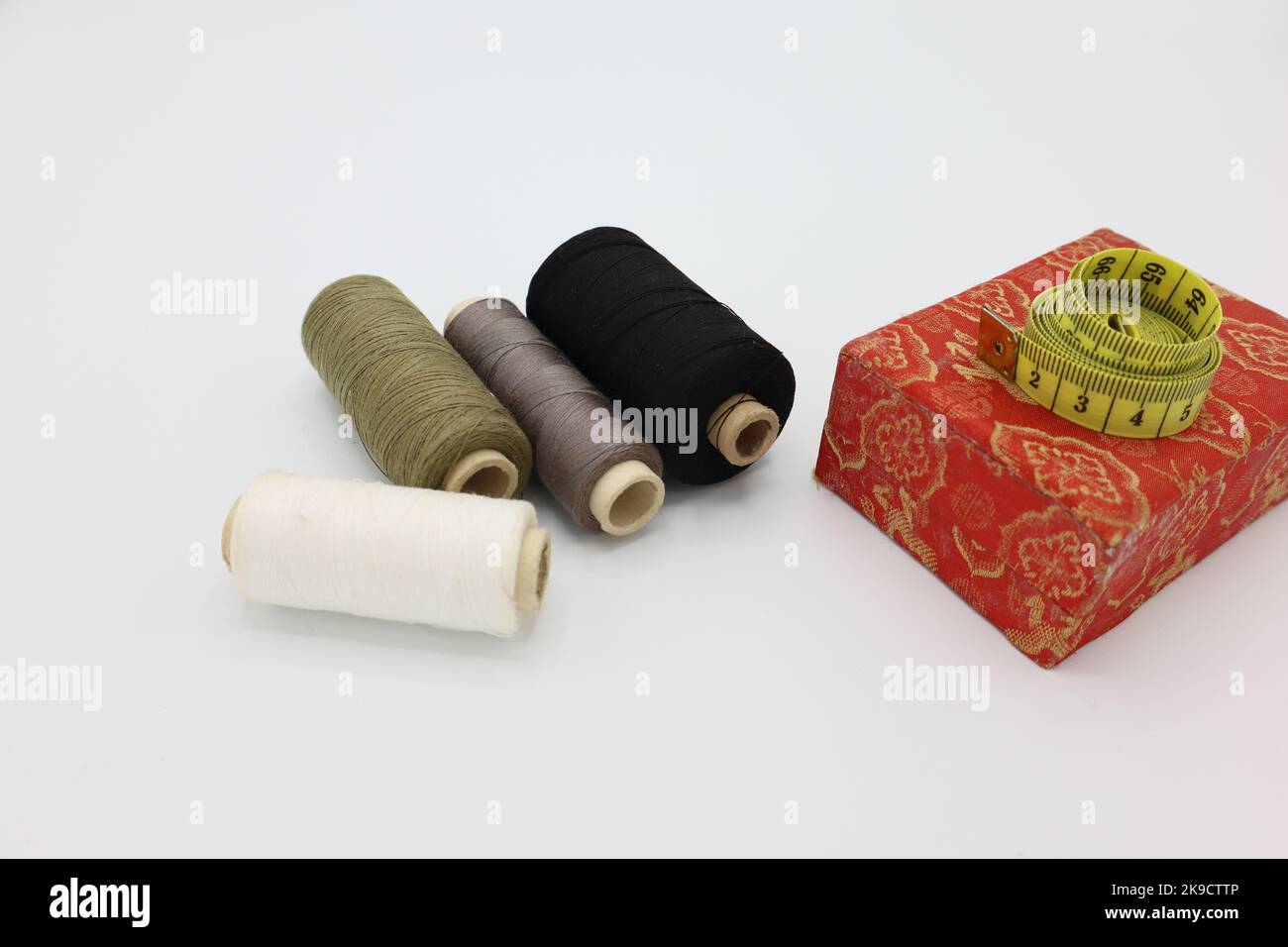 Sewing accessories on a white background. Threads, measure tape and a ...