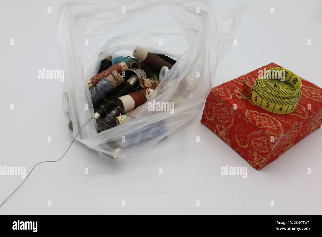 Sewing accessories on a white background. Threads in a plastic bag ...