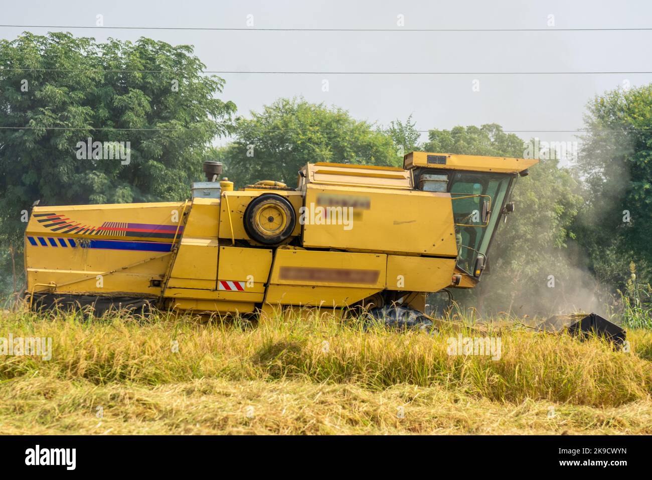 Combine harvester machine in the paddy field Stock Photo - Alamy