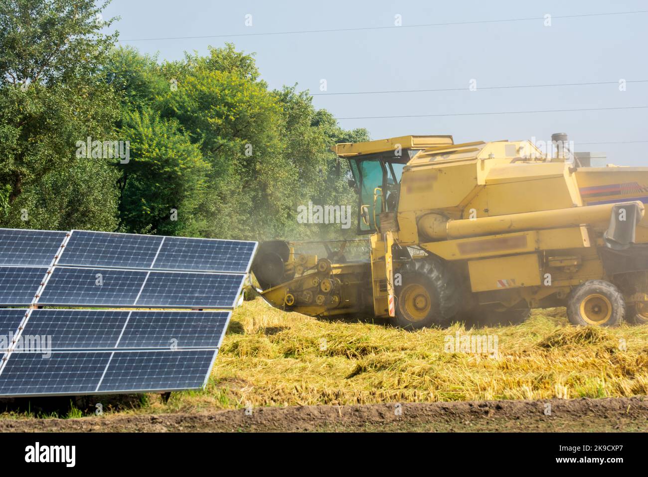 Solar panels and combine harvester machine in the field Stock Photo - Alamy