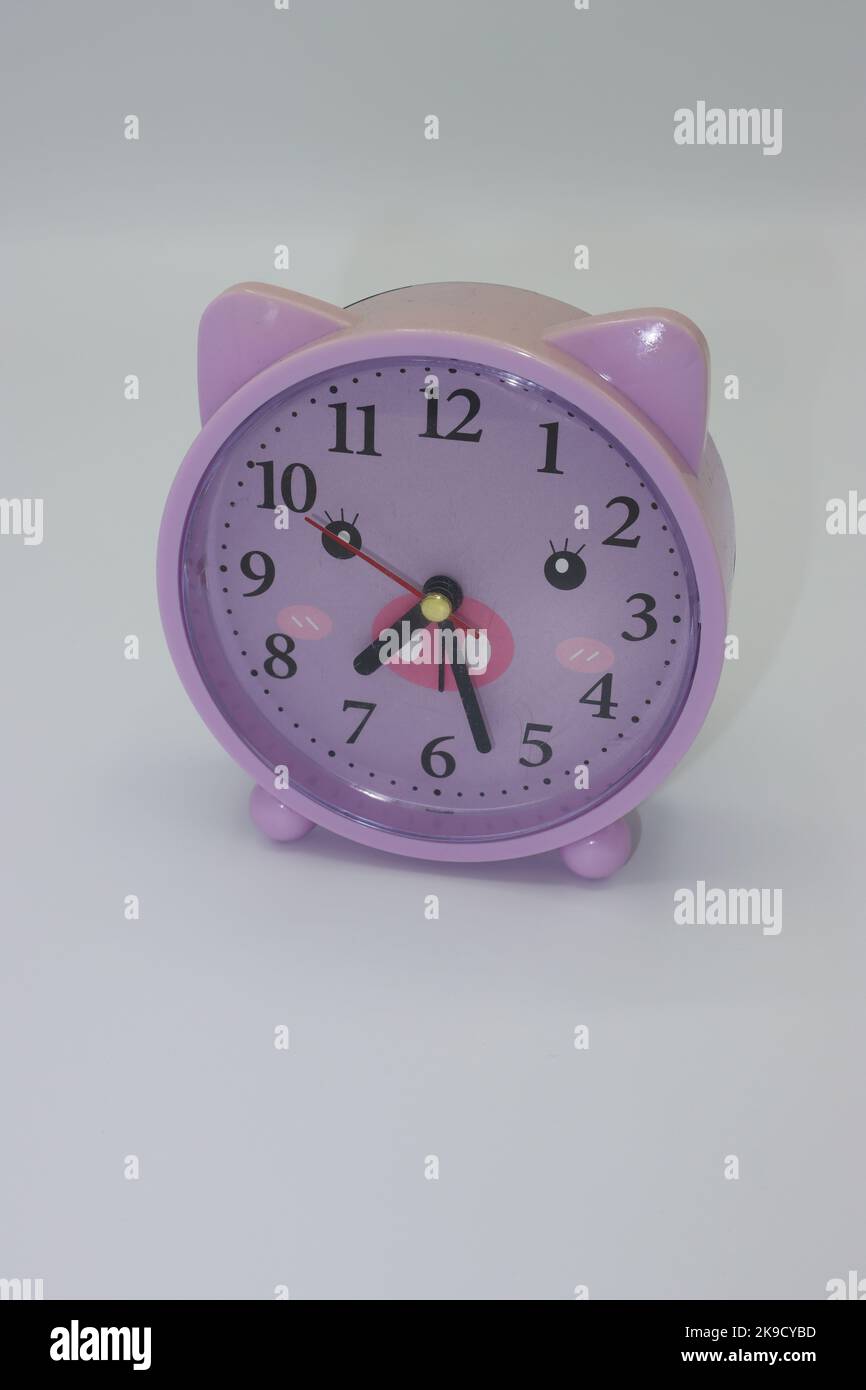 Purple of lilac colored clock in a piglet form on a white background ...