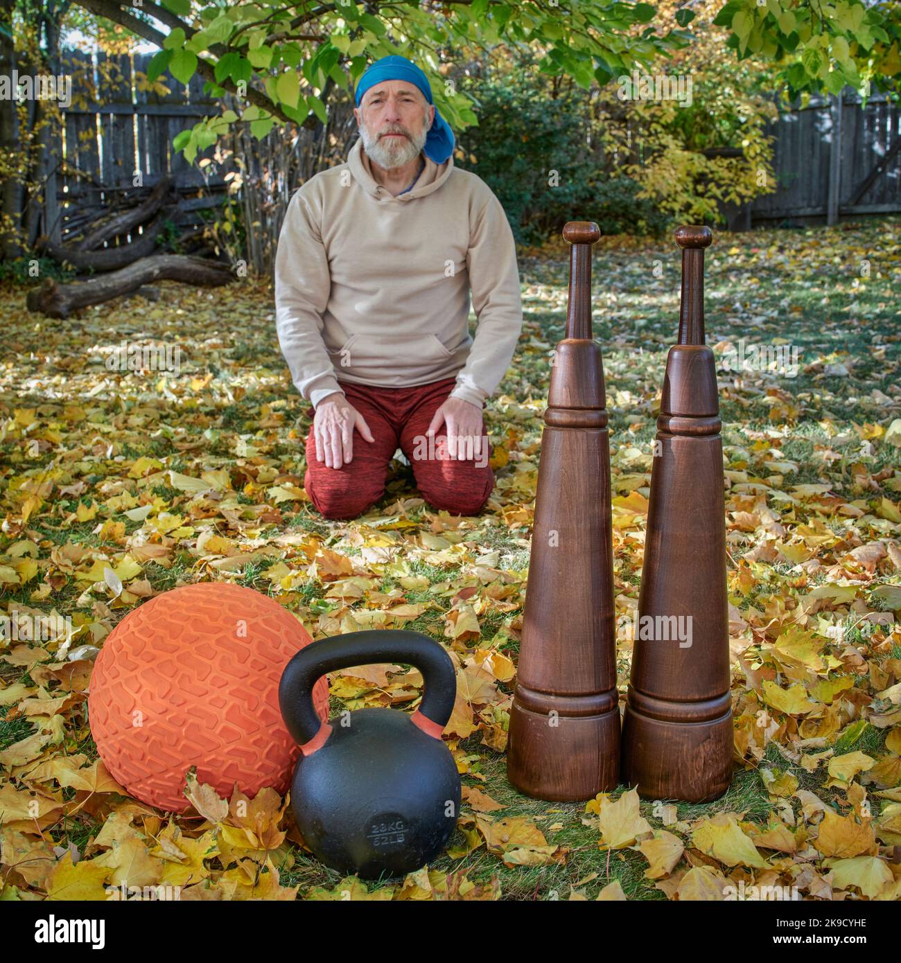 heavy iron kettlebell, slam ball and wooden Persian clubs in a backyard ...