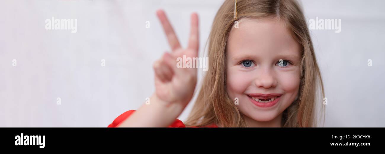 Smiling little girl without front teeth gesture two fingers up Stock ...