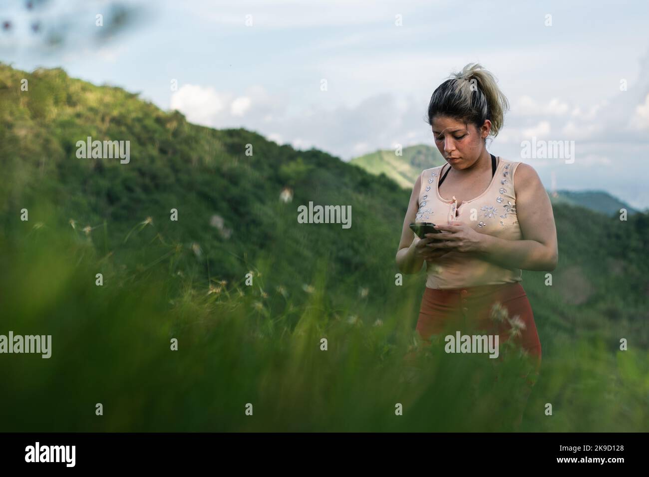 beautiful young latina woman, walking through nature while checking her ...