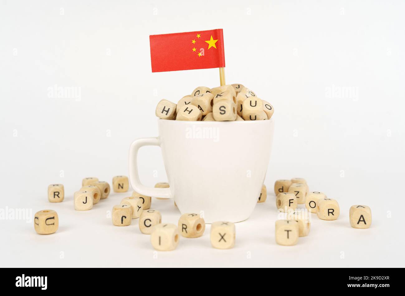 The flag of China sticks out of a cup with cubes on which letters are ...