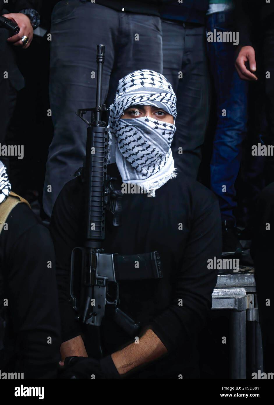 A masked Palestinian gunman appeared carrying a weapon while receiving ...