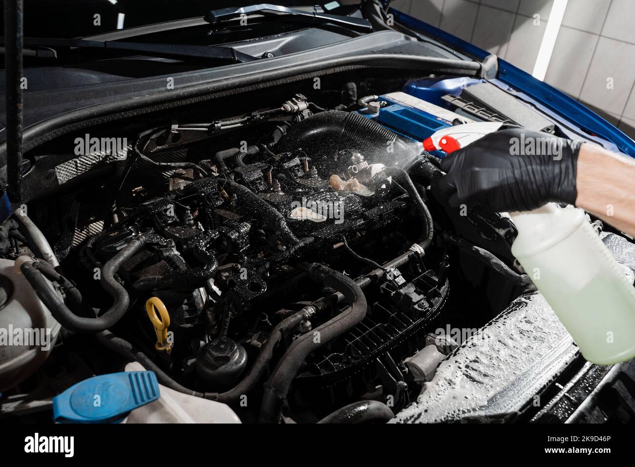 Spraying detergent on car engine. Washing car engine with spray and ...