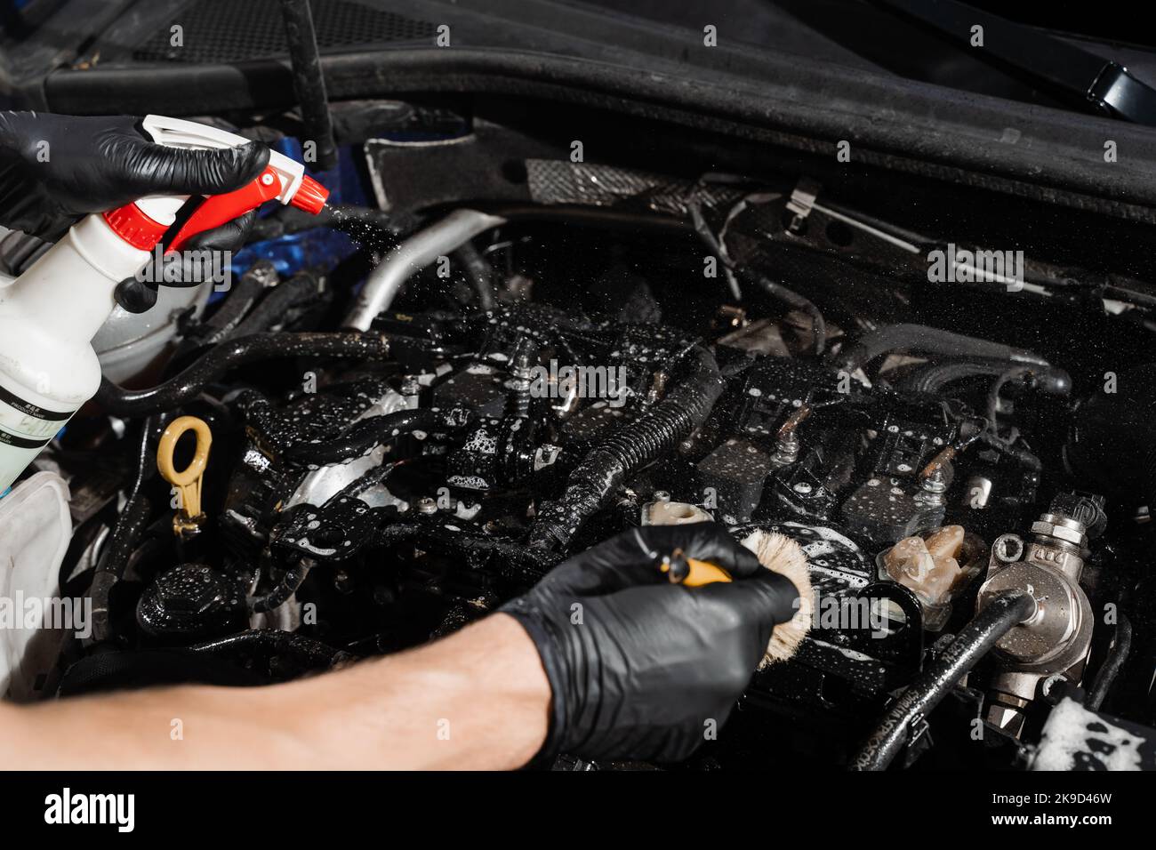 Spraying detergent on car engine. Washing car engine with spray and ...