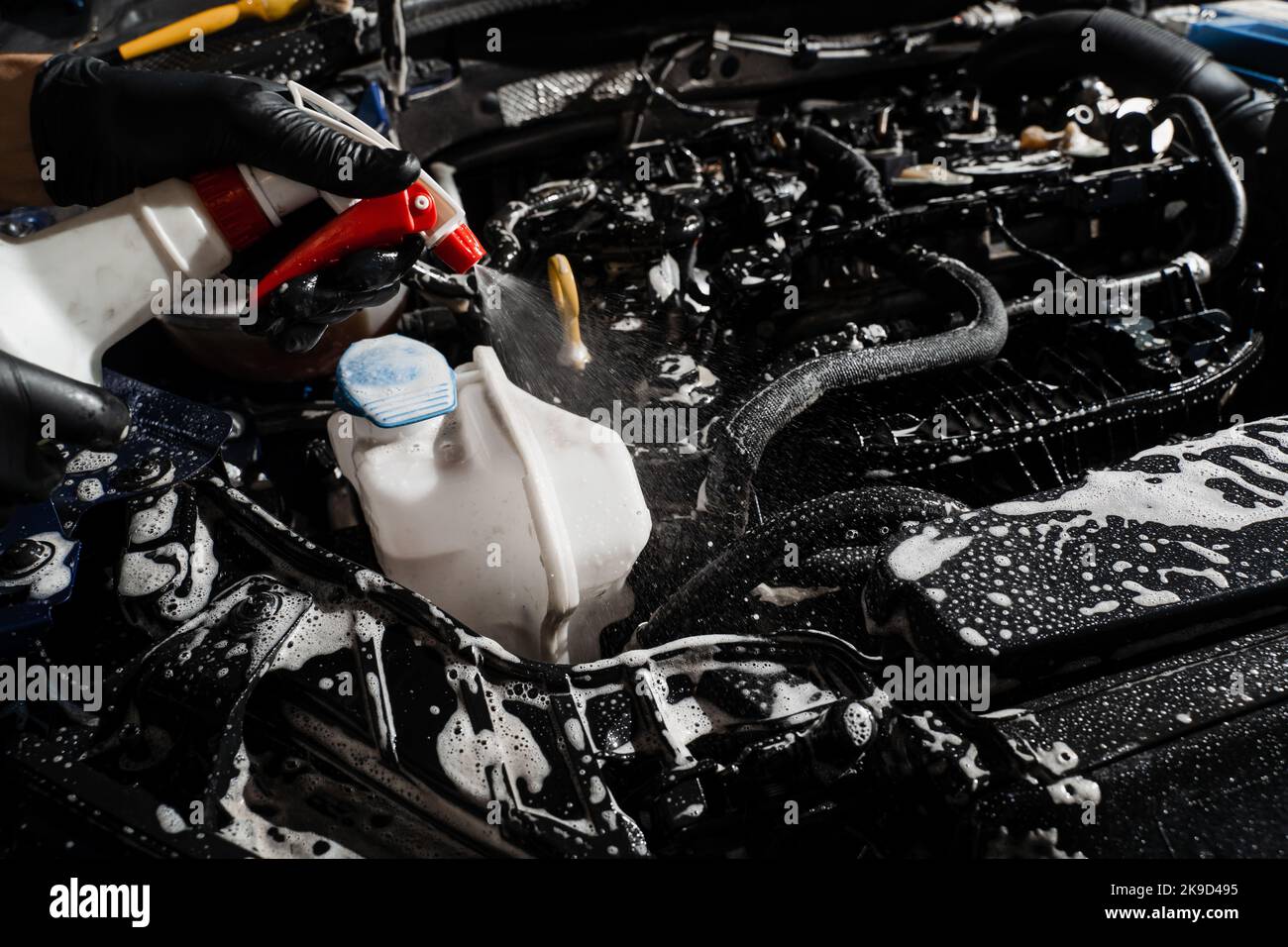 Spraying detergent on car engine. Washing car engine with spray and ...