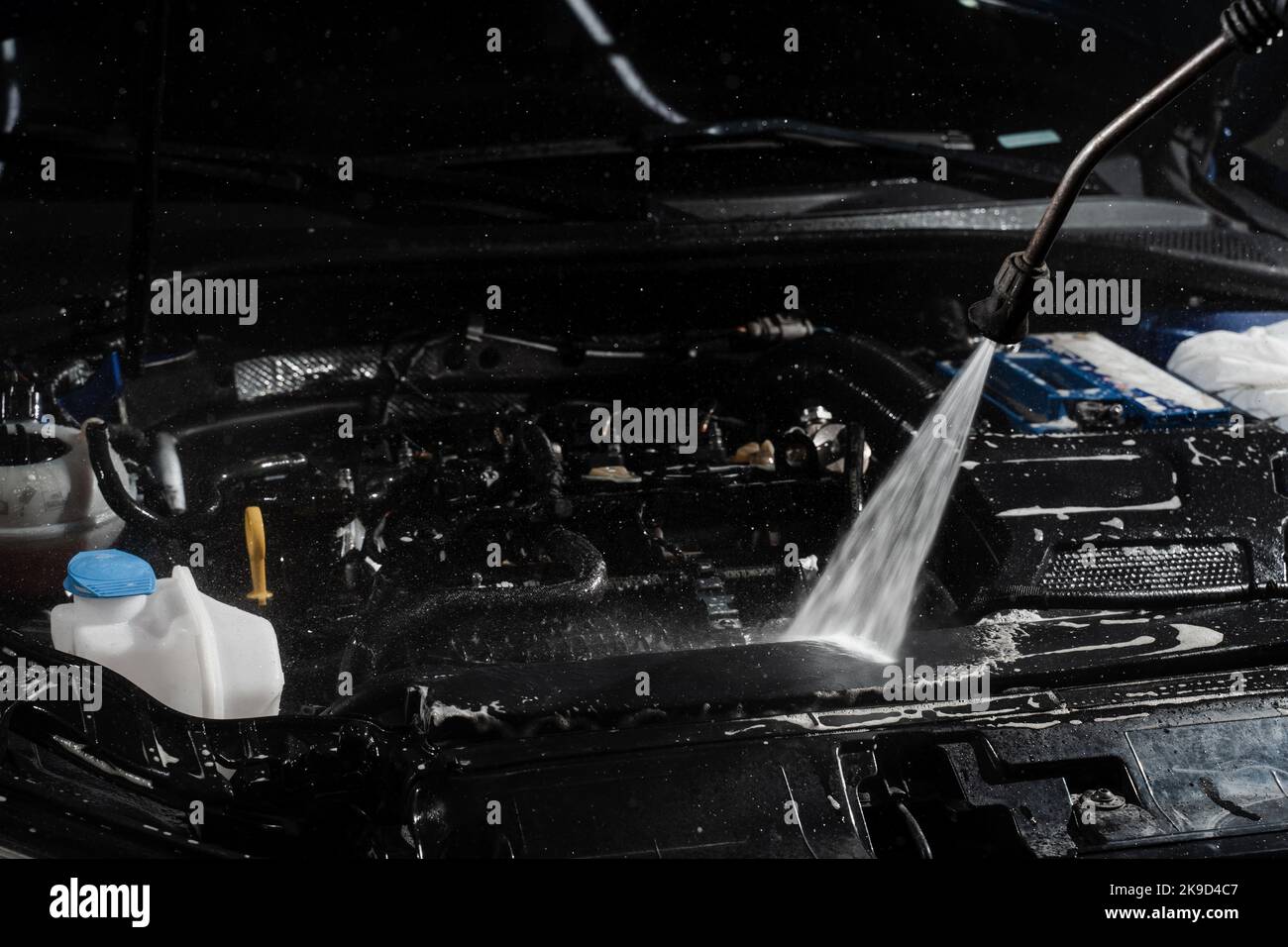 Detailing cleaning motor from dust and dirt. Pouring water on car ...