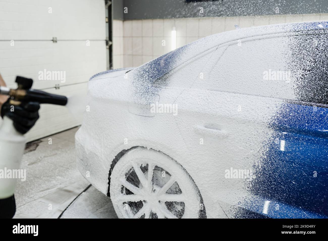 Process of spraying foam on the car body in the garage. Second phase of ...