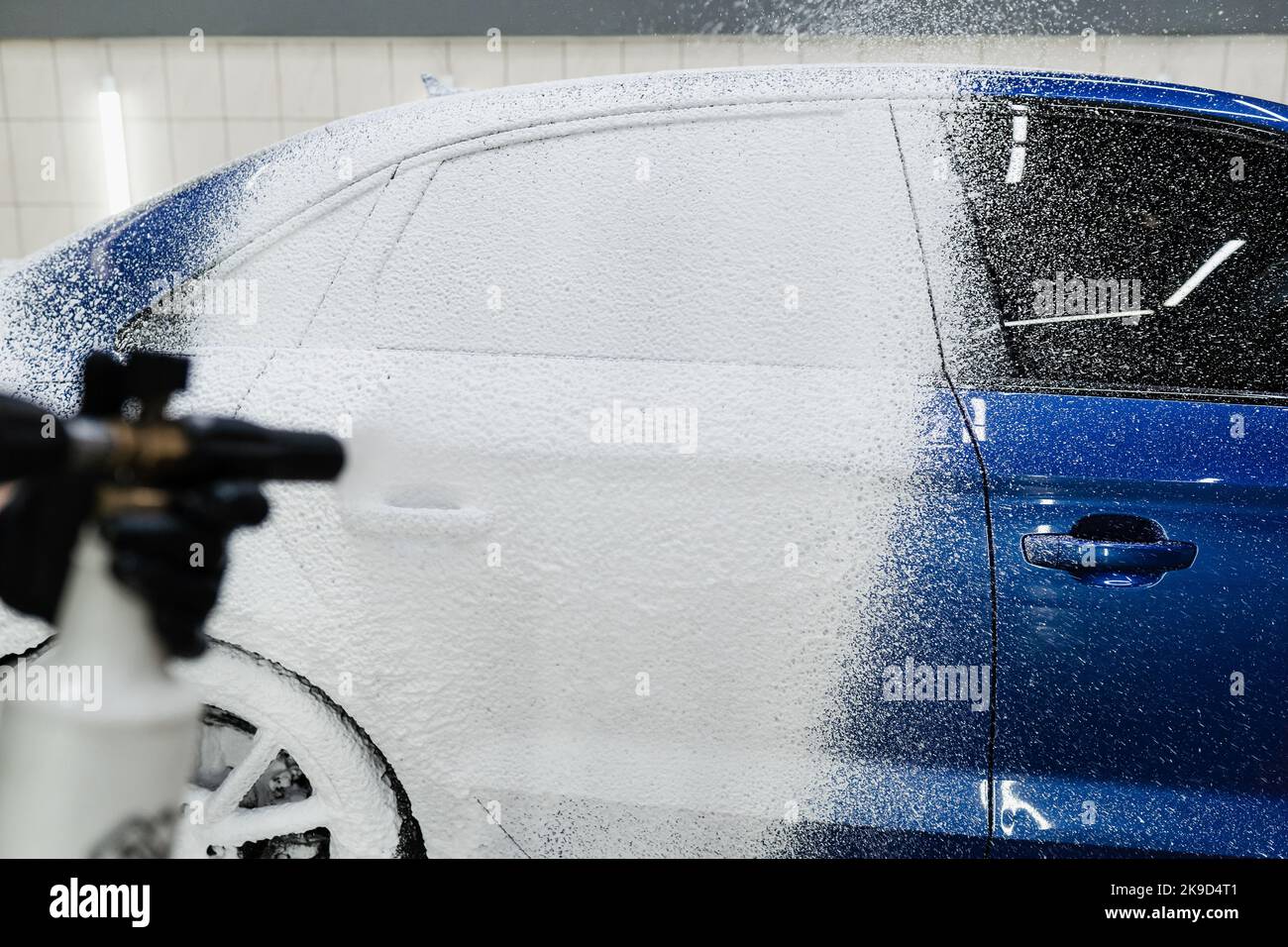 Process of spraying foam on the car body in the garage. Second phase of ...