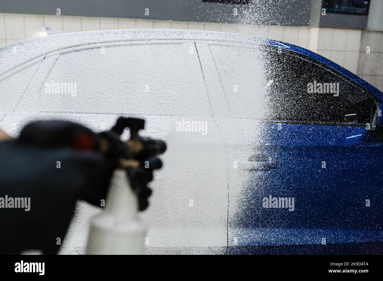 Process of spraying foam on the car body in the garage. Second phase of ...