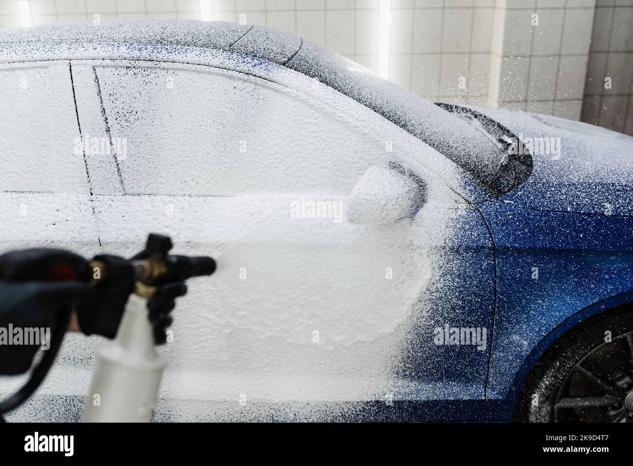 Process of spraying foam on the car body in the garage. Second phase of ...
