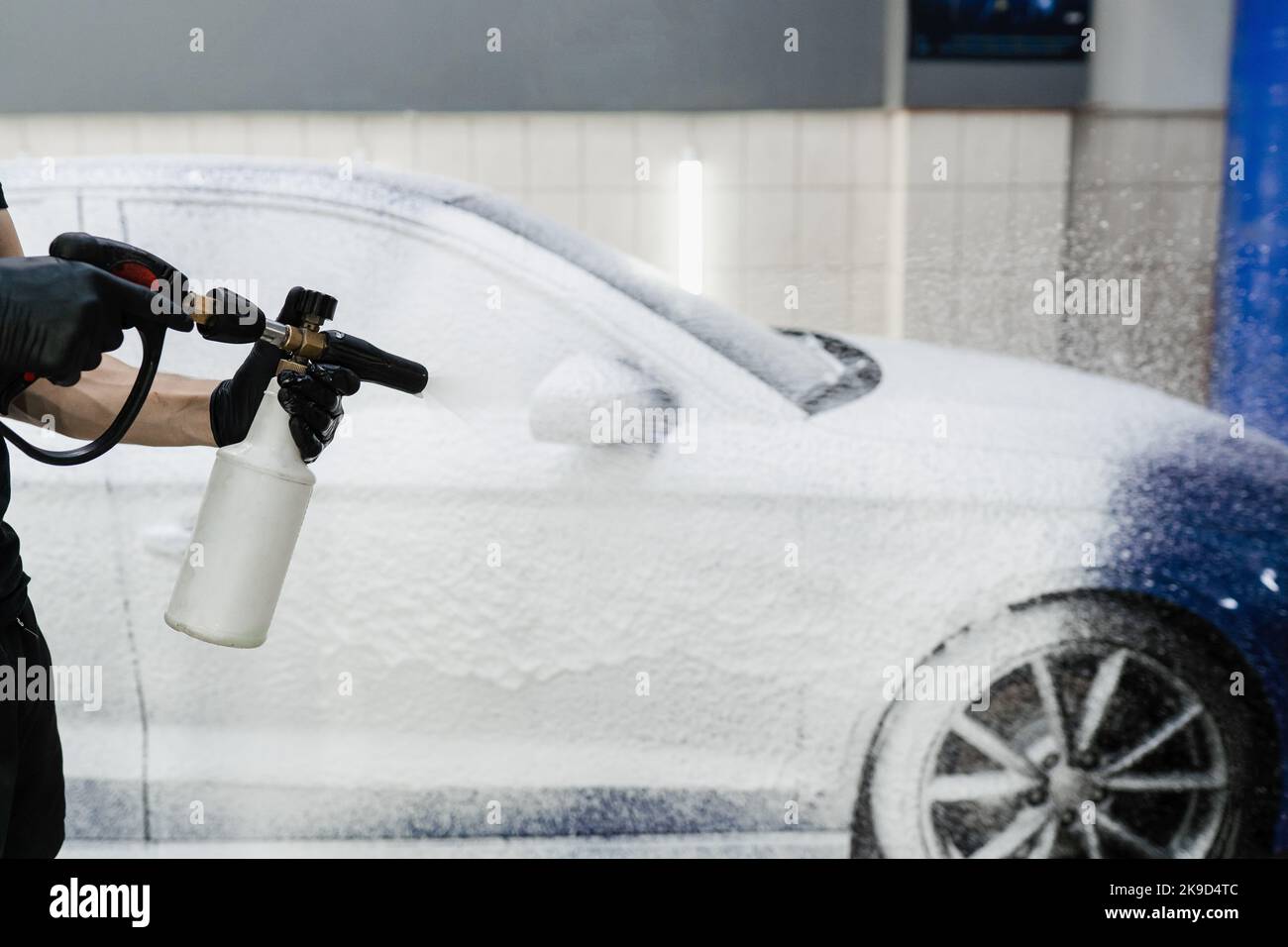 Process of spraying foam on the car body in the garage. Second phase of ...