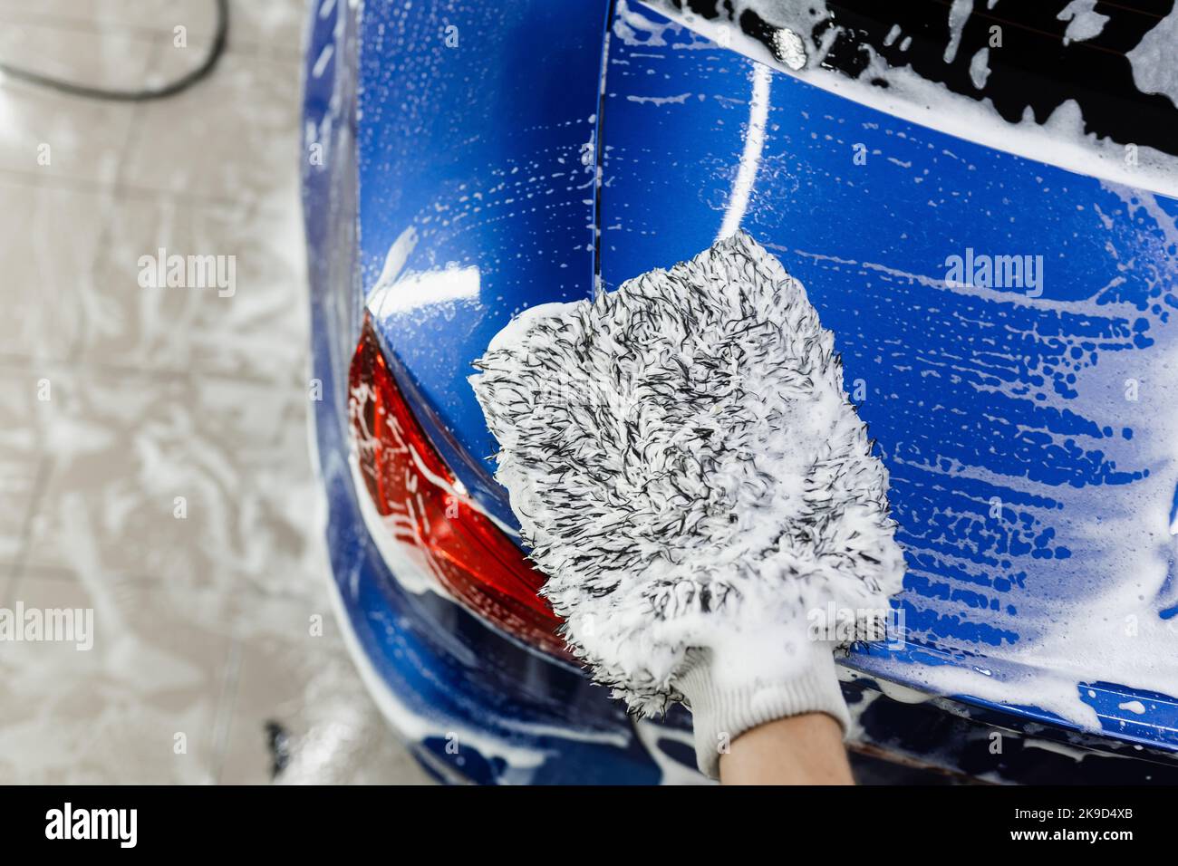 Car washer doing manual foam washing in auto detailing service. Hand ...