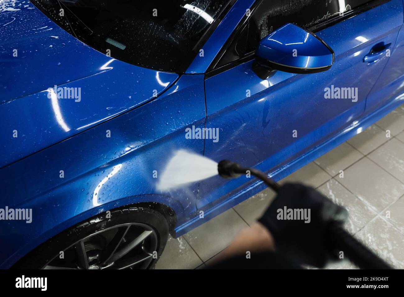 Spraying water on car to wash off foam in the garage. Process of ...