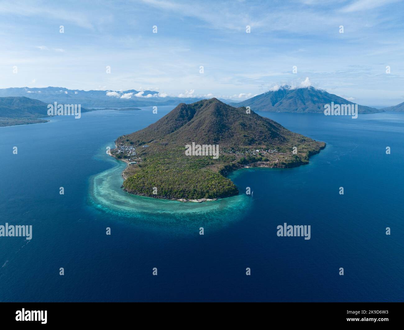 A fringing reef grows along the edge of a remote, volcanic island near ...