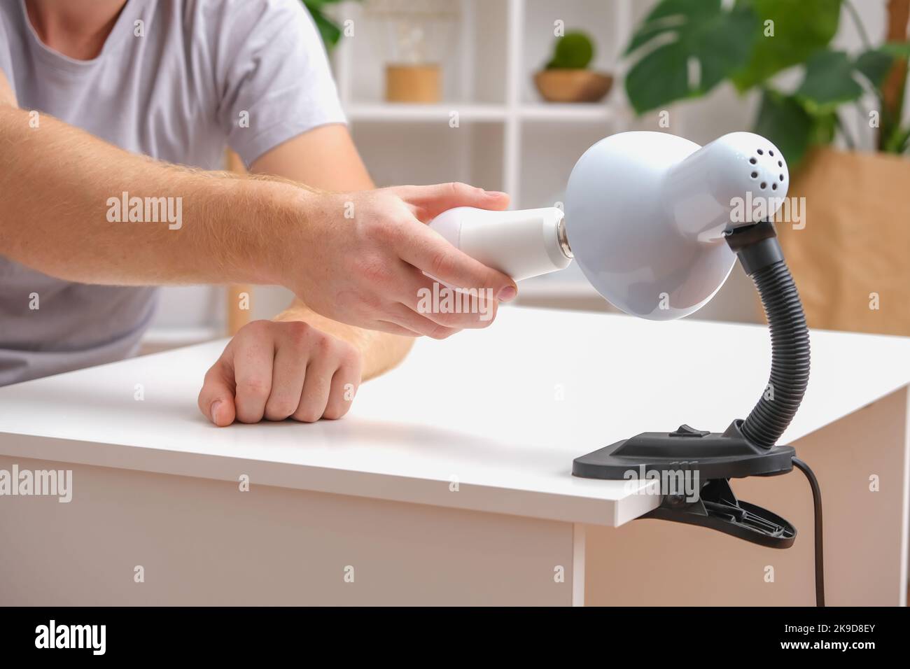 The man changes the lamp. Energy-saving lamp. Replacement of an energy ...